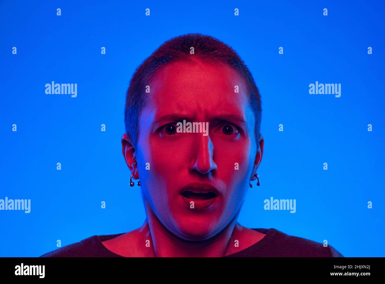 Close-up young scared woman, student with short hair looking at camera ...