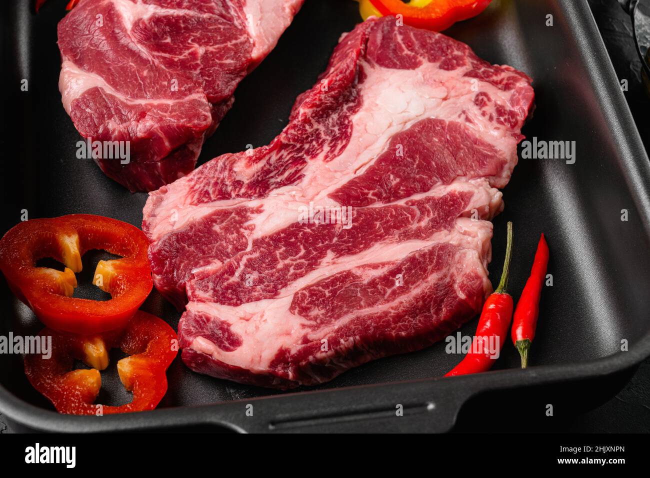 Raw marbled beef steaks set, on black dark stone table background Stock ...