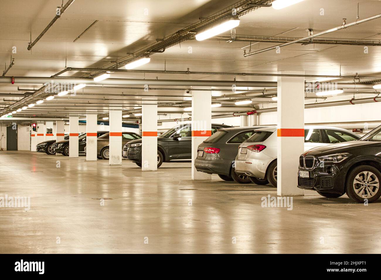 Underground parking lot in a modern building with row of cars ...