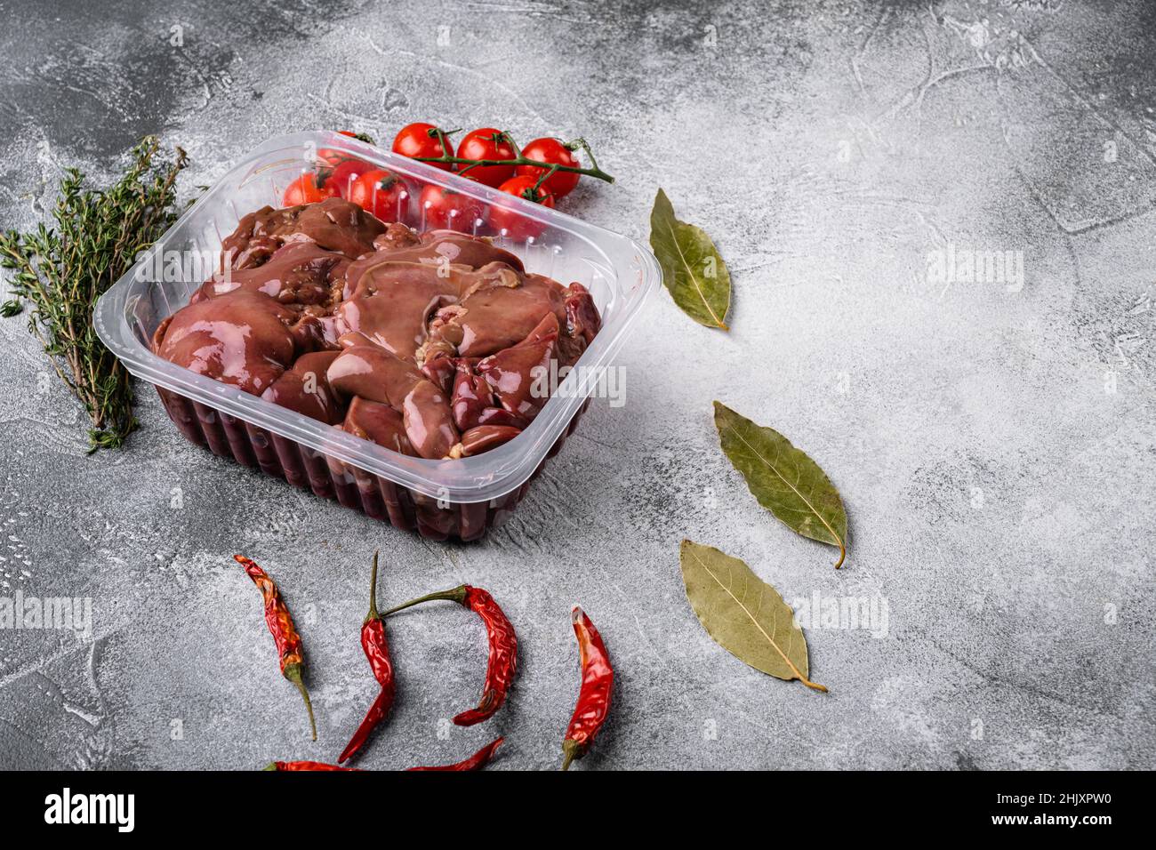 Fresh chicken liver in a disposable one-off packaging set, on gray ...