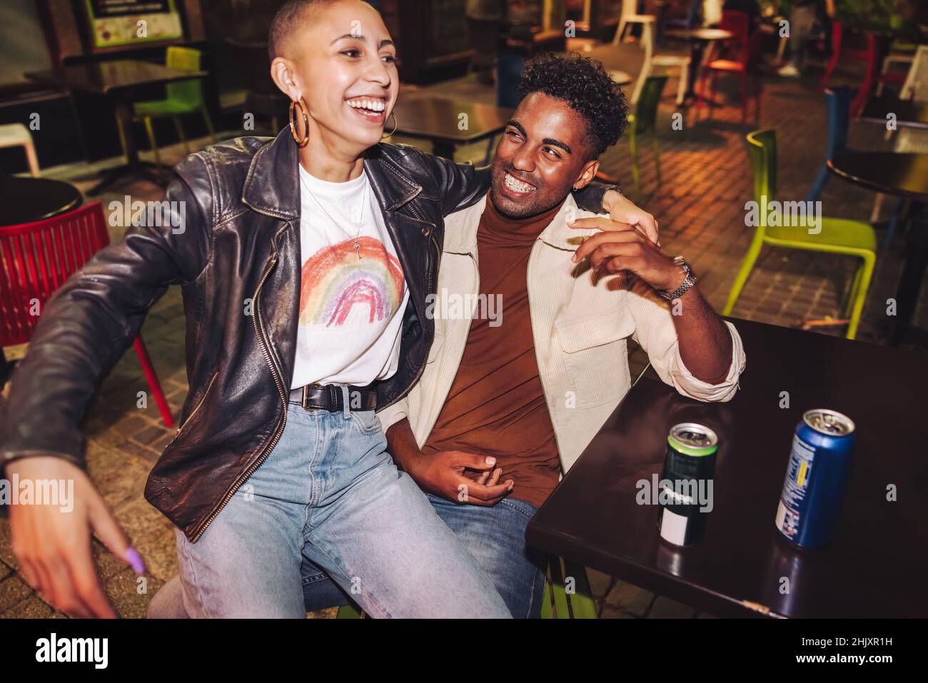 Two best friends laughing happily at an outdoor restaurant. Two ...
