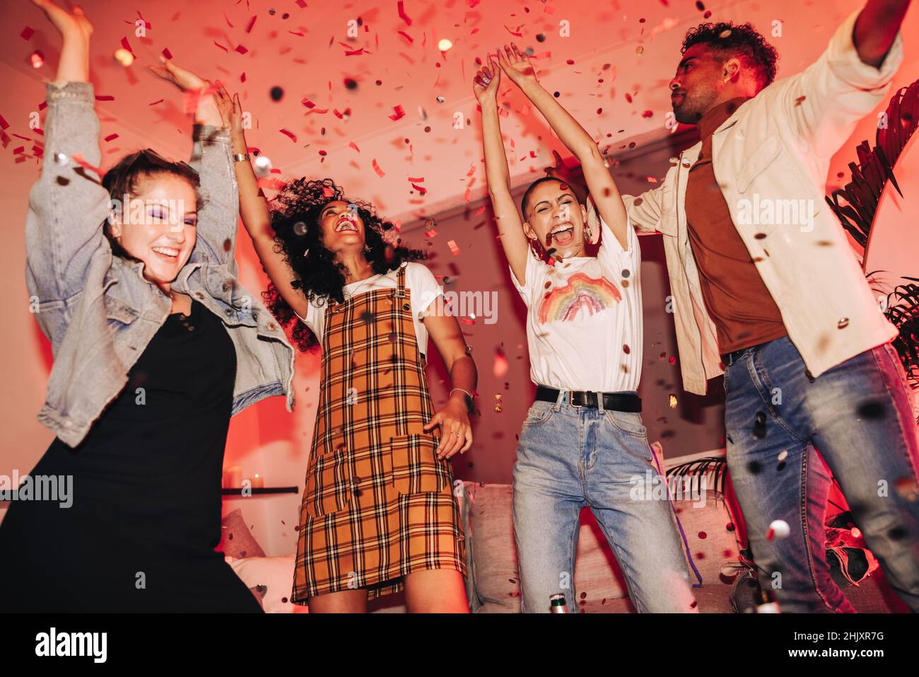 Friends having fun at a house party. Group of cheerful friends dancing ...