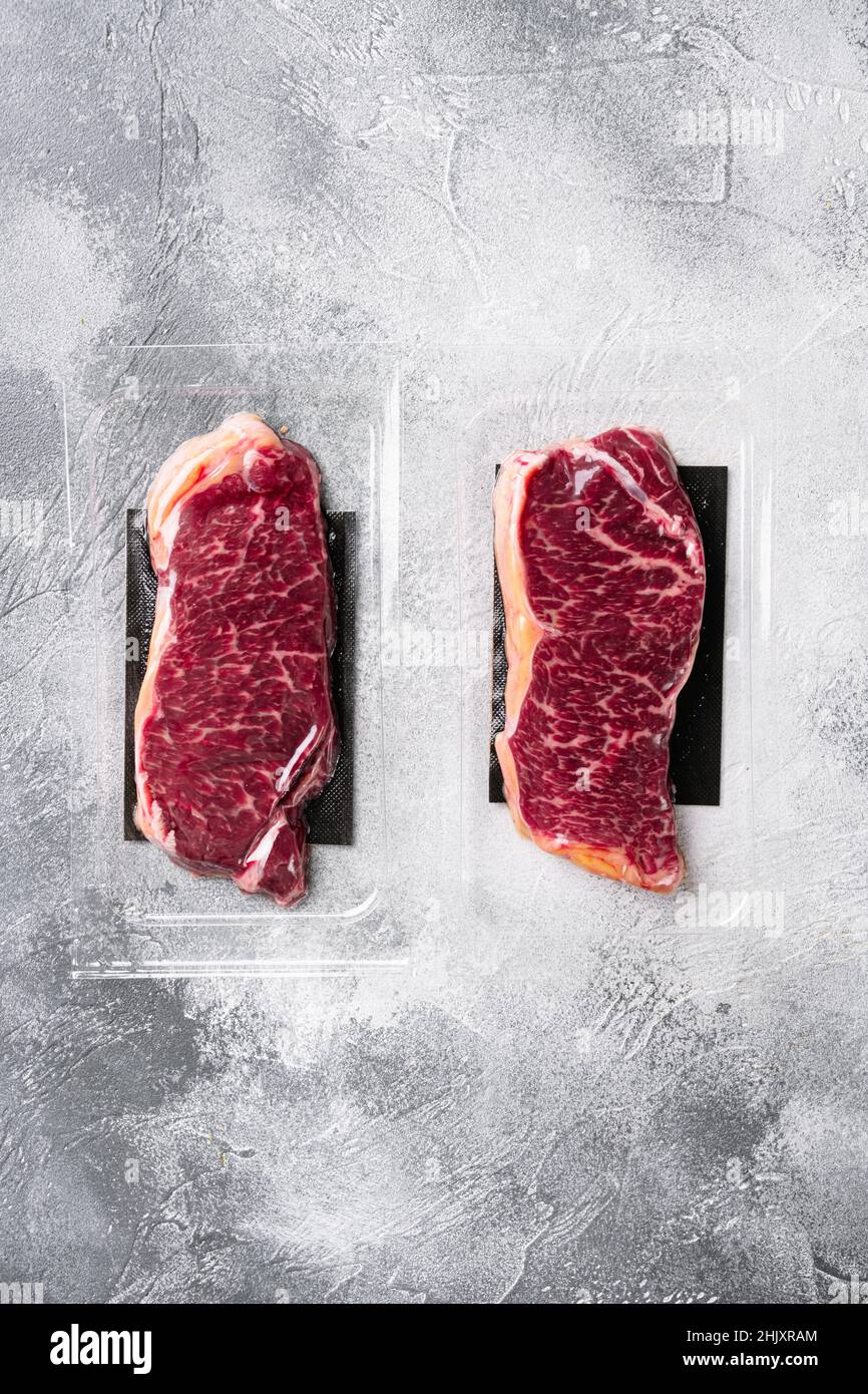 Raw Striploin marbled beef steak vacuum Packed set, on gray stone table ...
