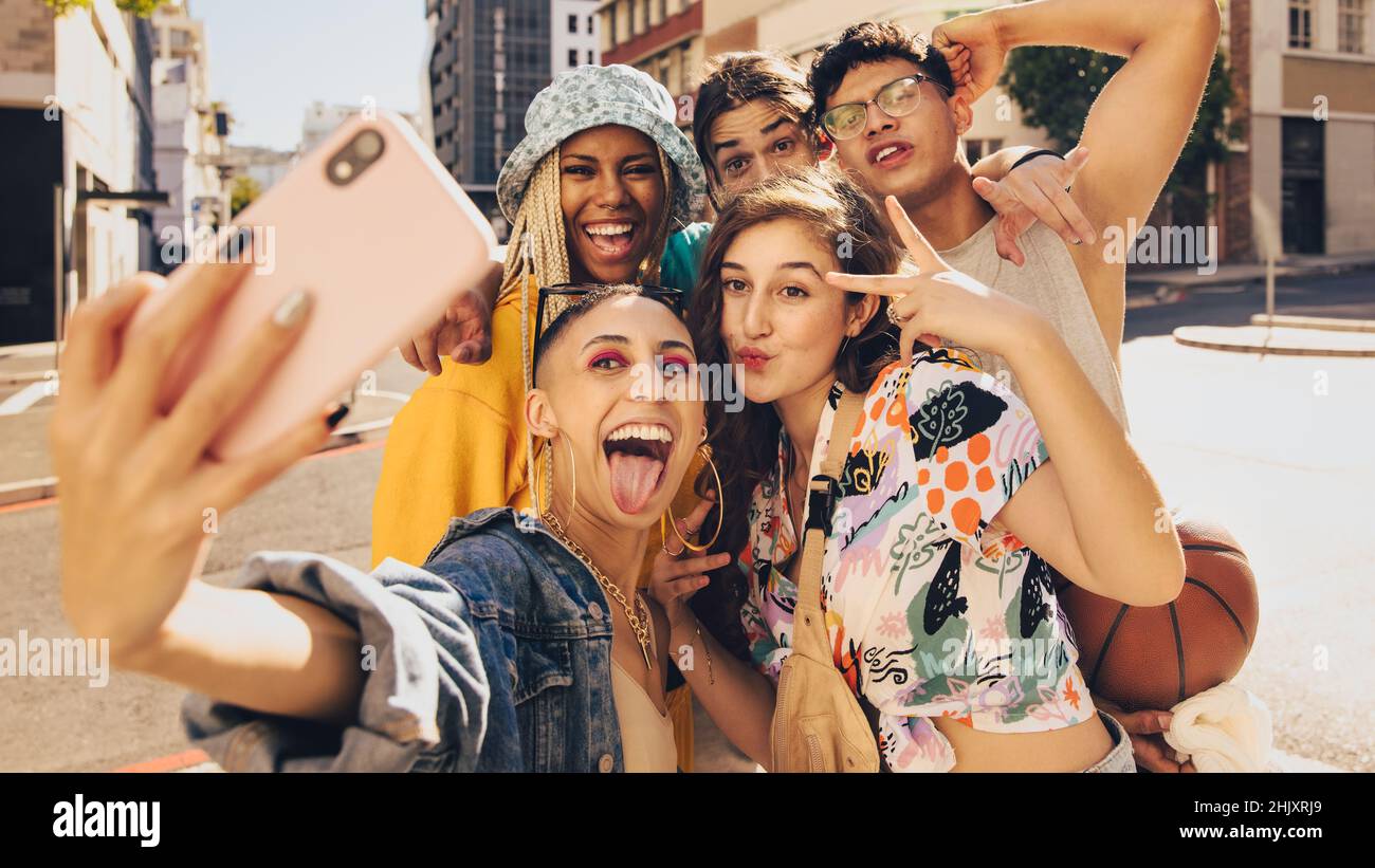 Vibrant selfies. Group of multiethnic young people posing for a selfie together outdoors ...