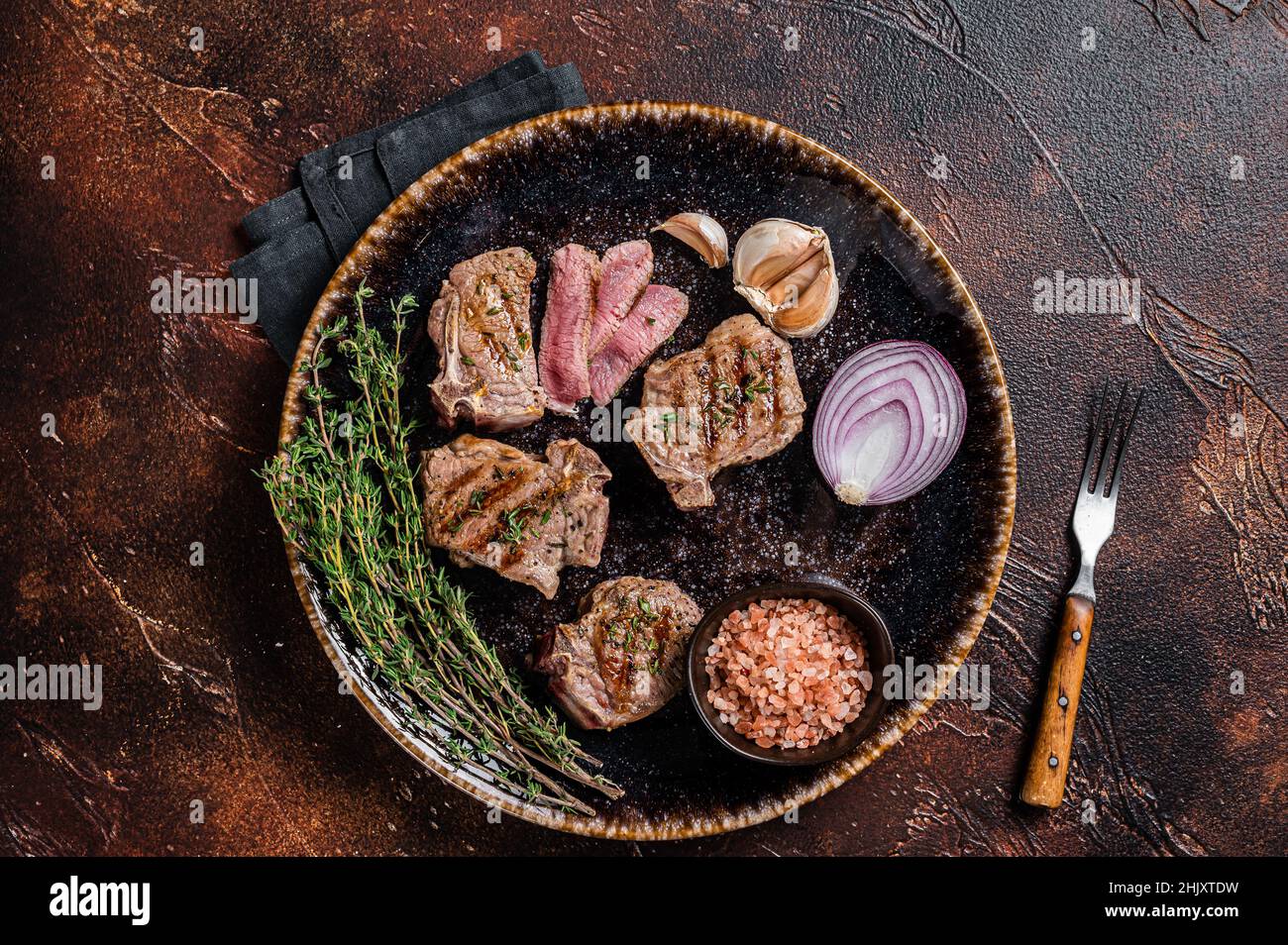 Barbecue Grilled lamb loin chops steaks, saddle in a plate with herbs ...