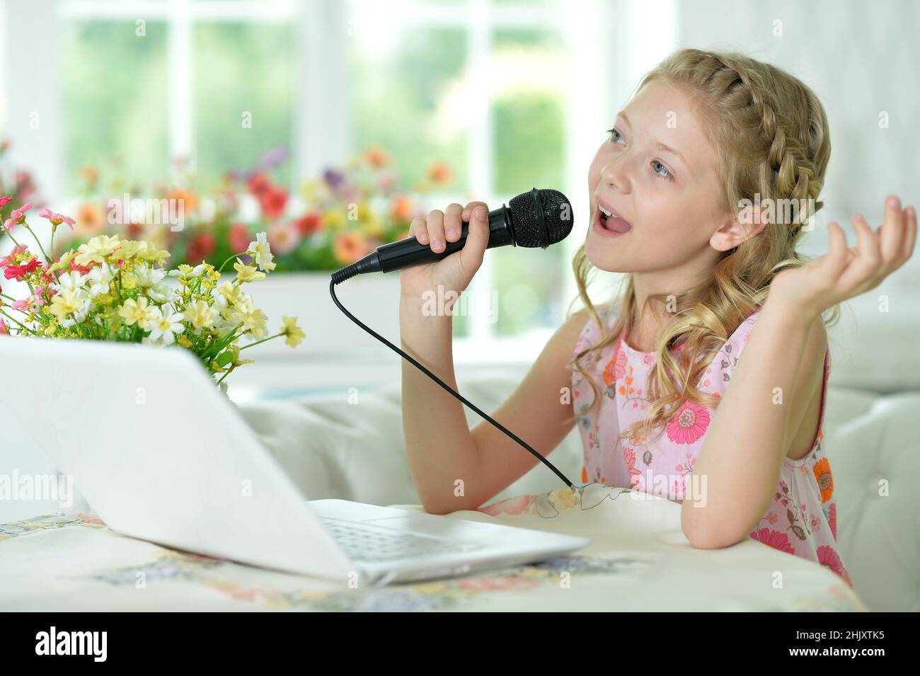 Portrait of little girl with laptop singing Stock Photo - Alamy
