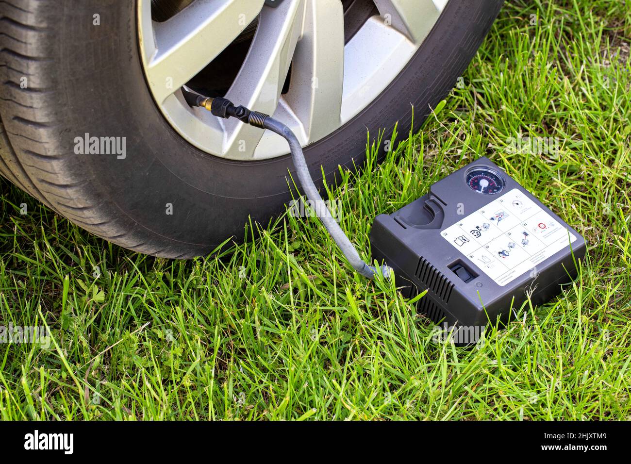 A car compressor pumps air into a car wheel when it is punctured. Close ...