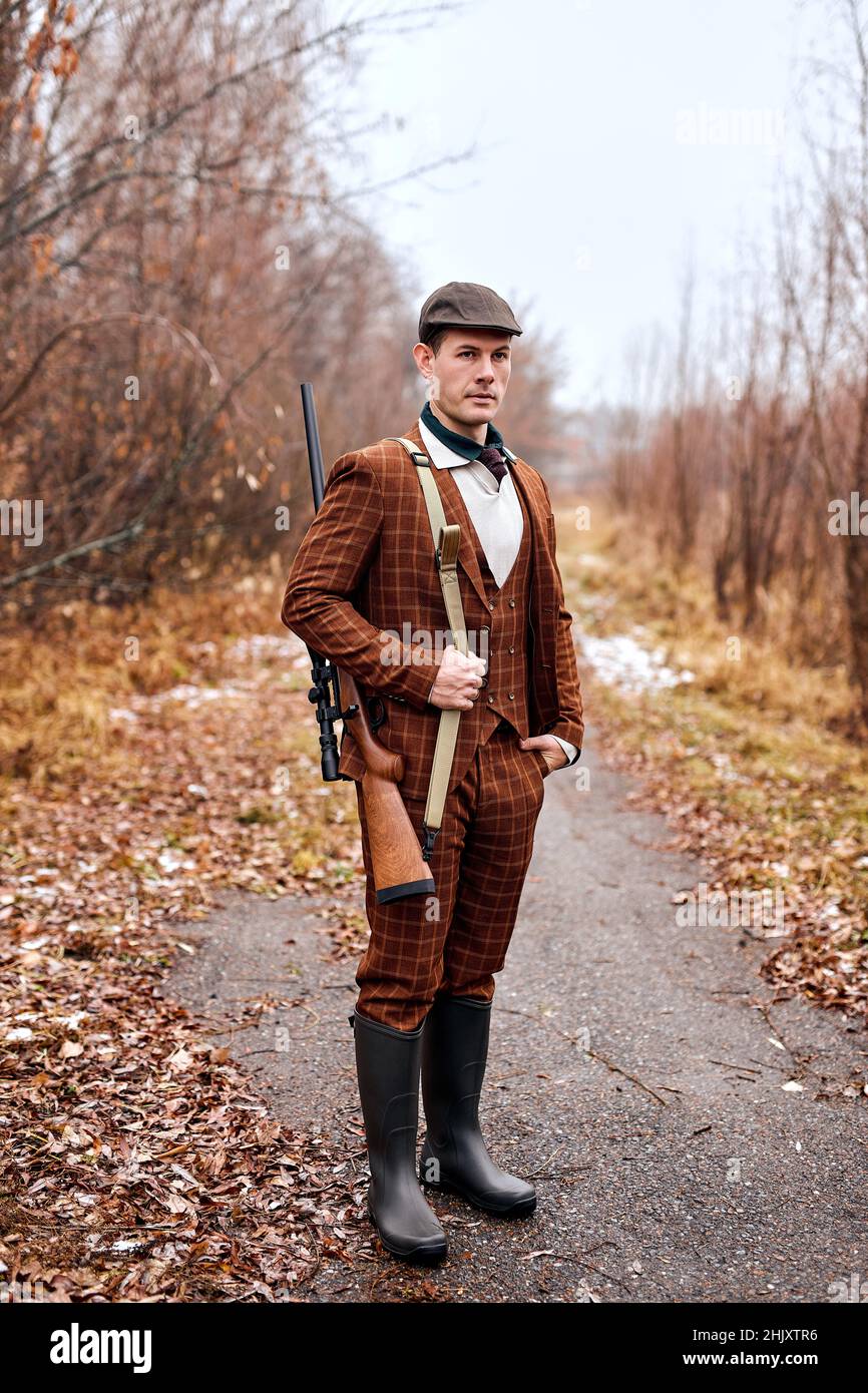 Young male hunter is going to hunt, dressed in brown stylish suit and ...