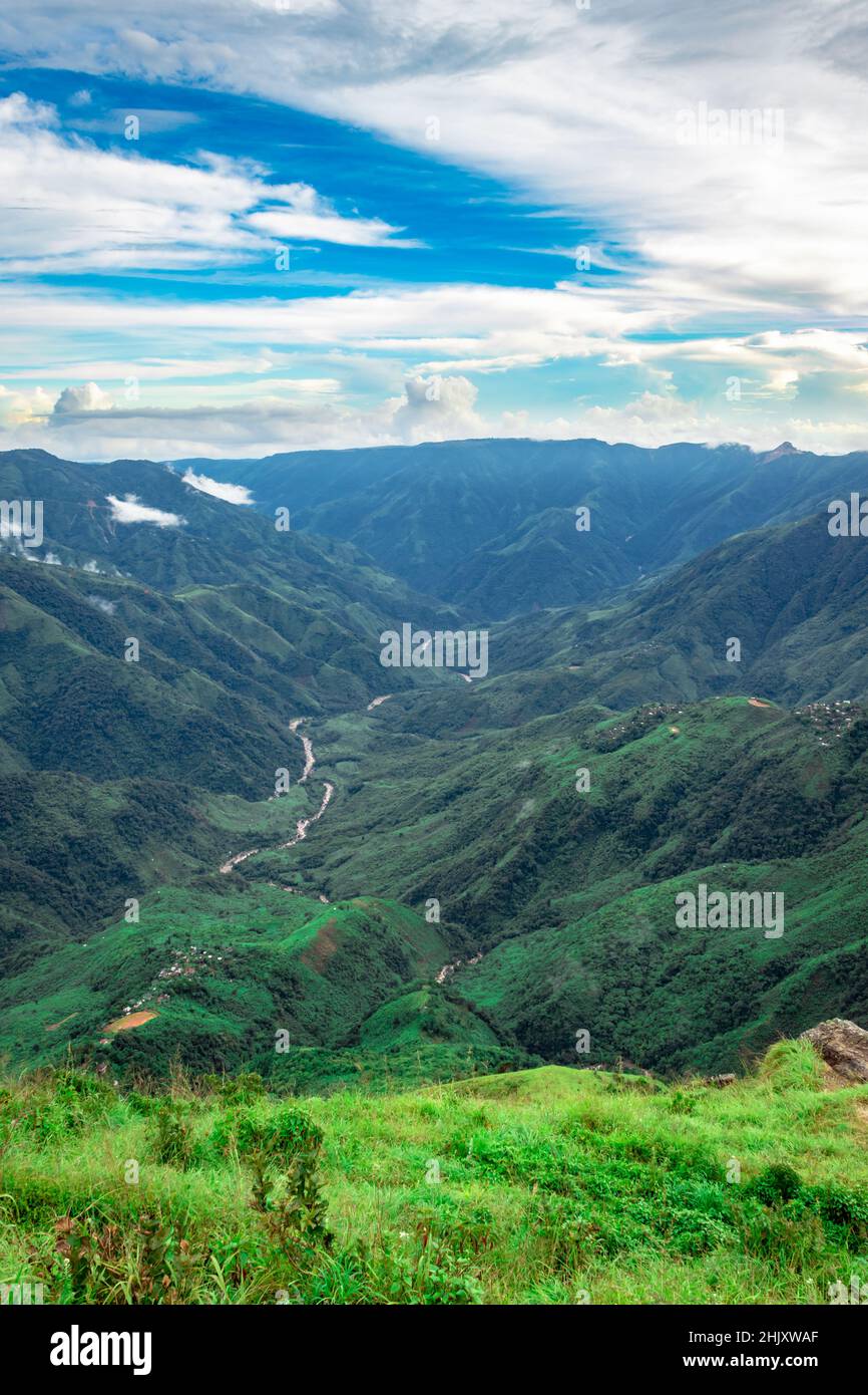 mountain valley with dramatic sunset sky and low clouds at evening ...