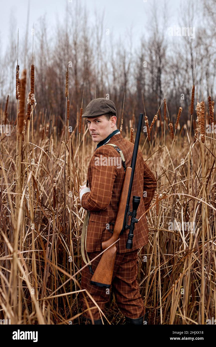 outdoor hunting on wild animals at autumn season. Man holding shotgun ...