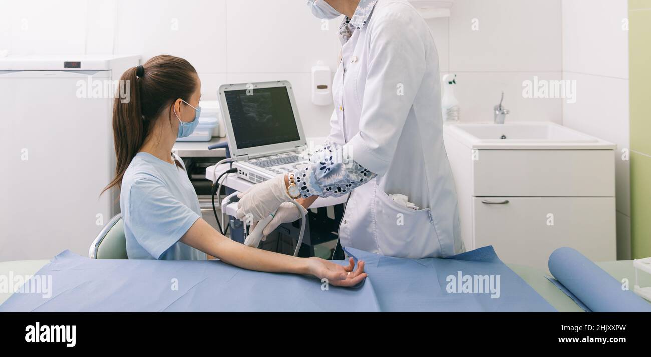 Doctor doing the ultrasound on the hand close up. Doctor demonstrates ...