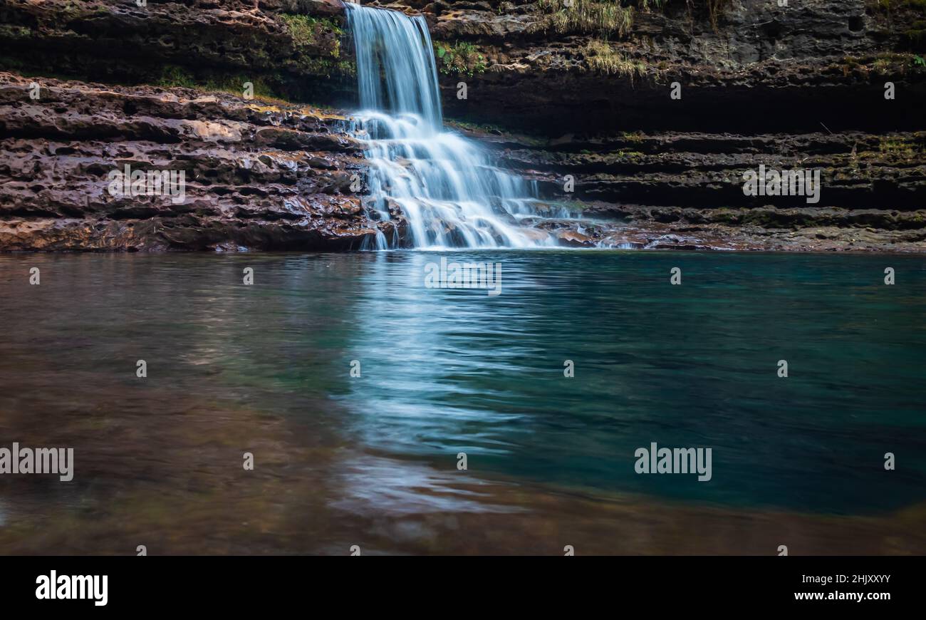 waterfall streams falling from mountain with blurred water surface at ...
