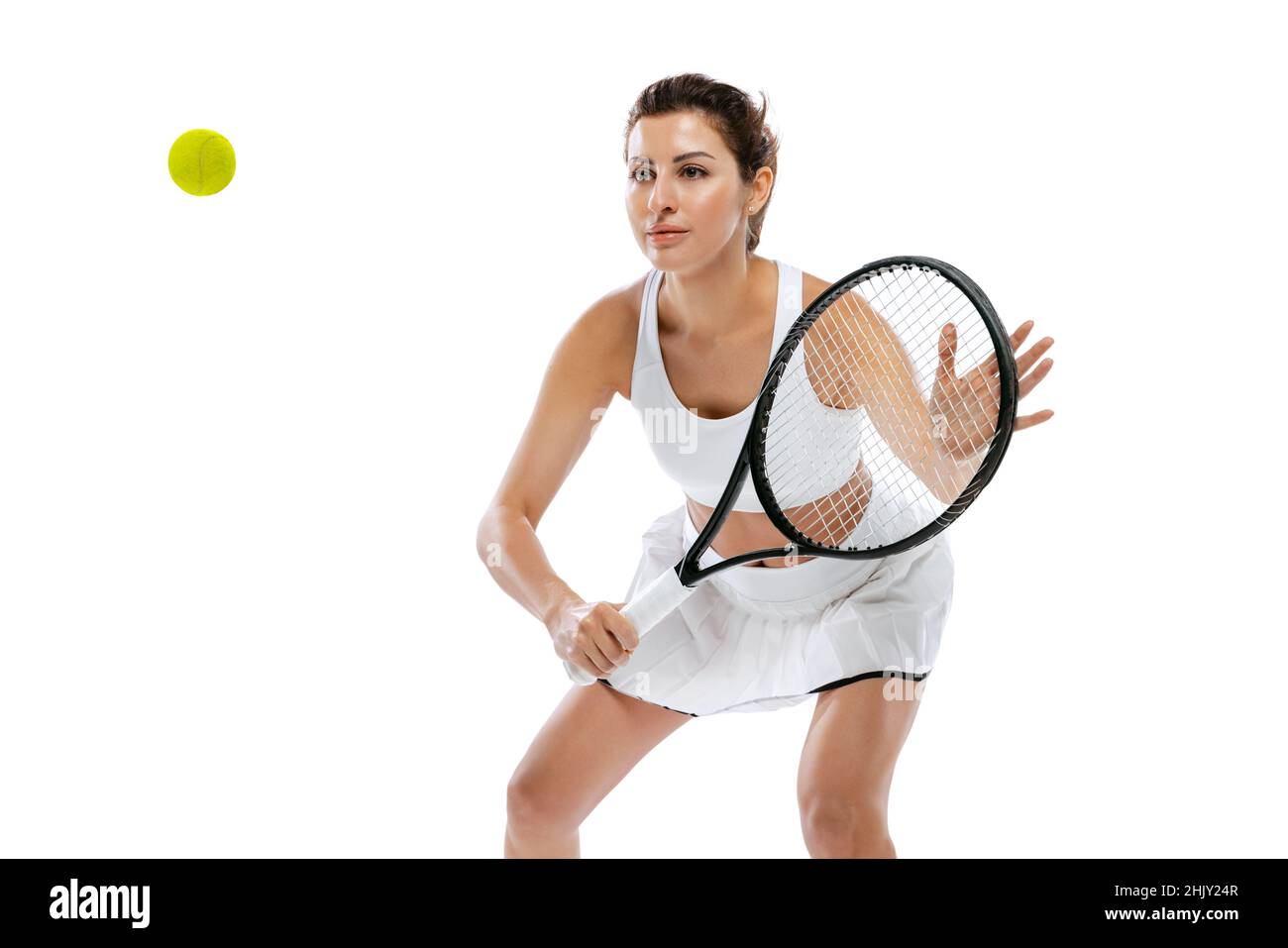 Studio shot of young sportive woman, tennis player training alone ...