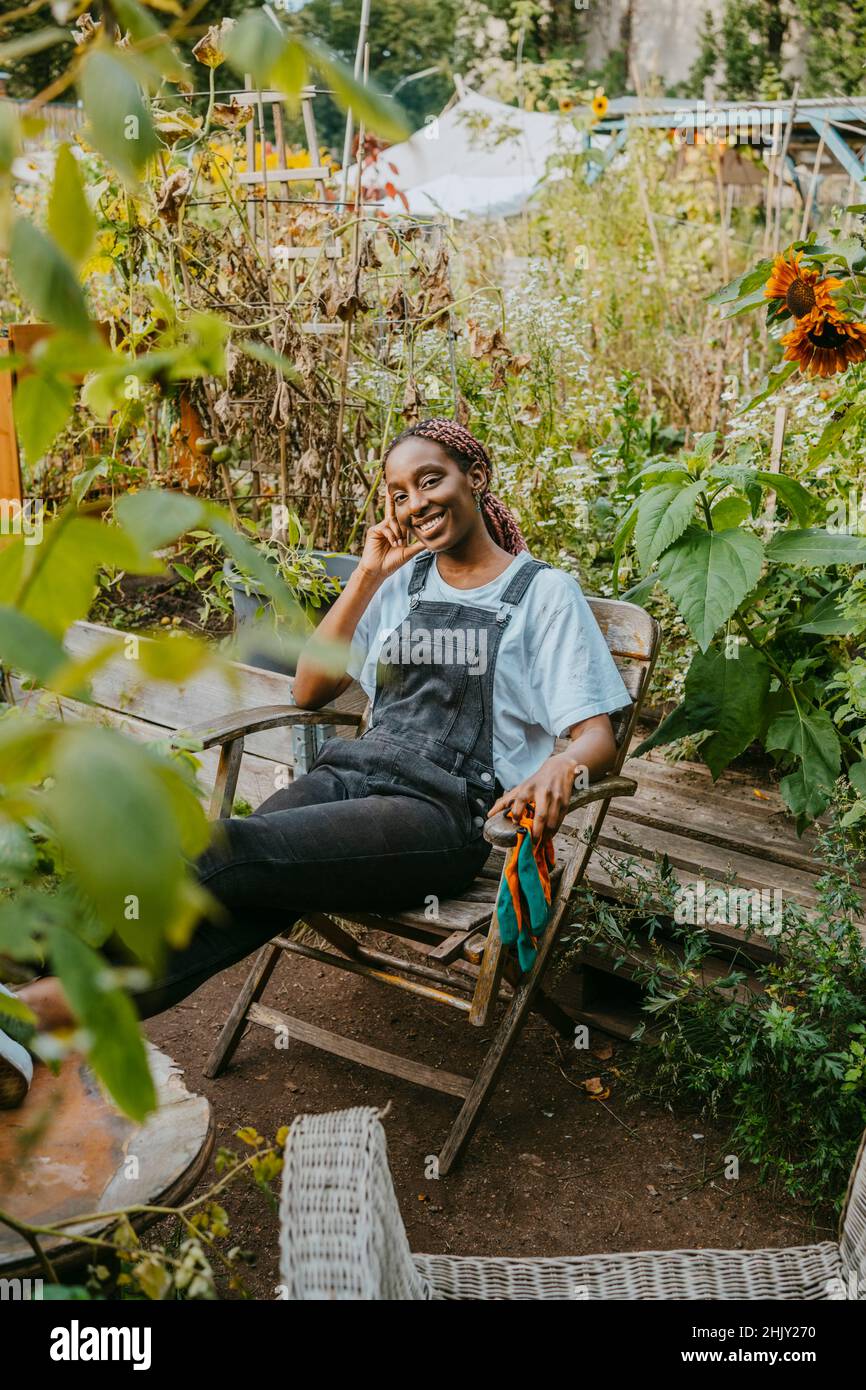 Portrait of female farmer sitting on chair in organic farm Stock Photo ...