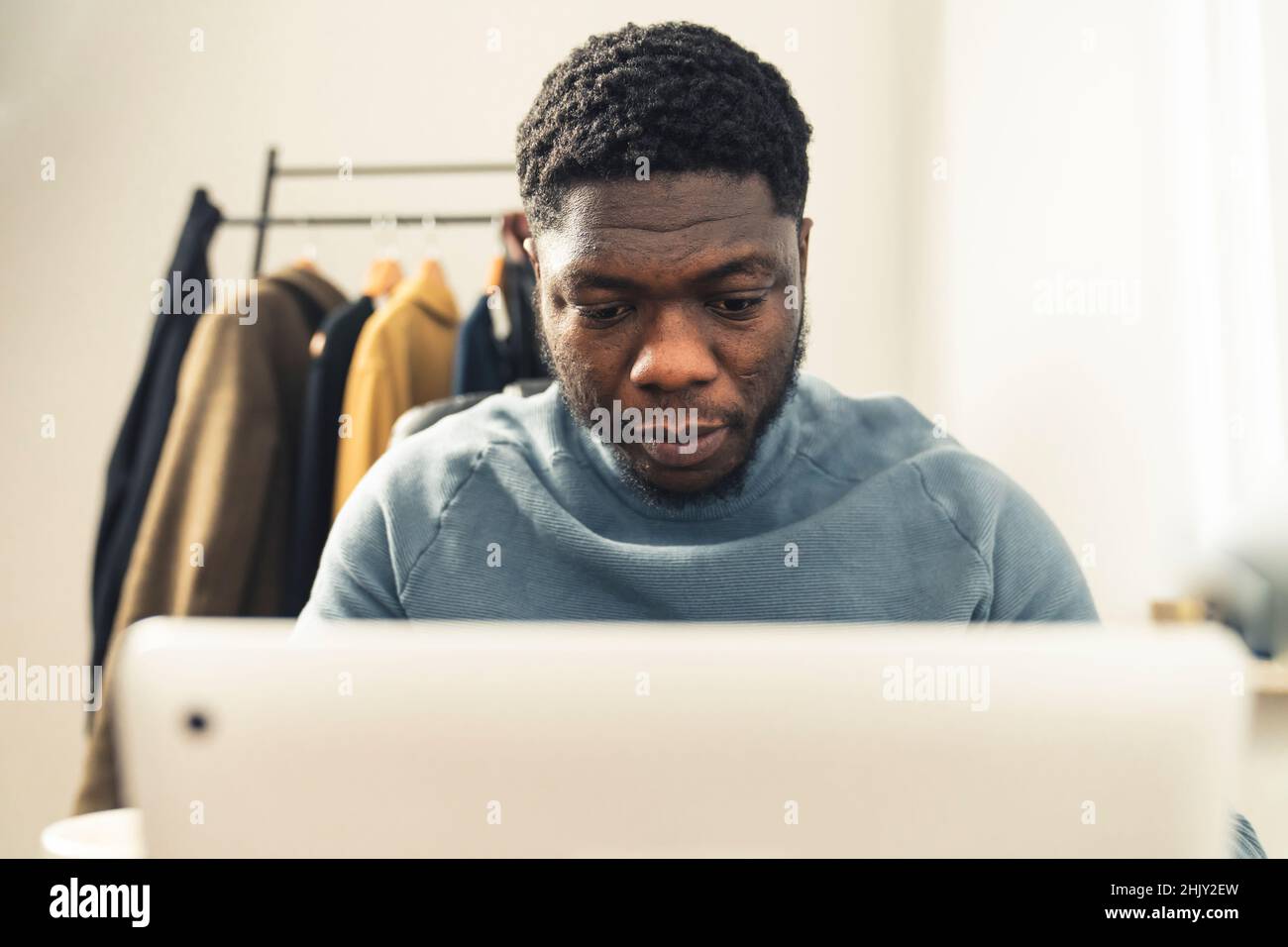 focussed intent black afroamerican working writing in front of white ...