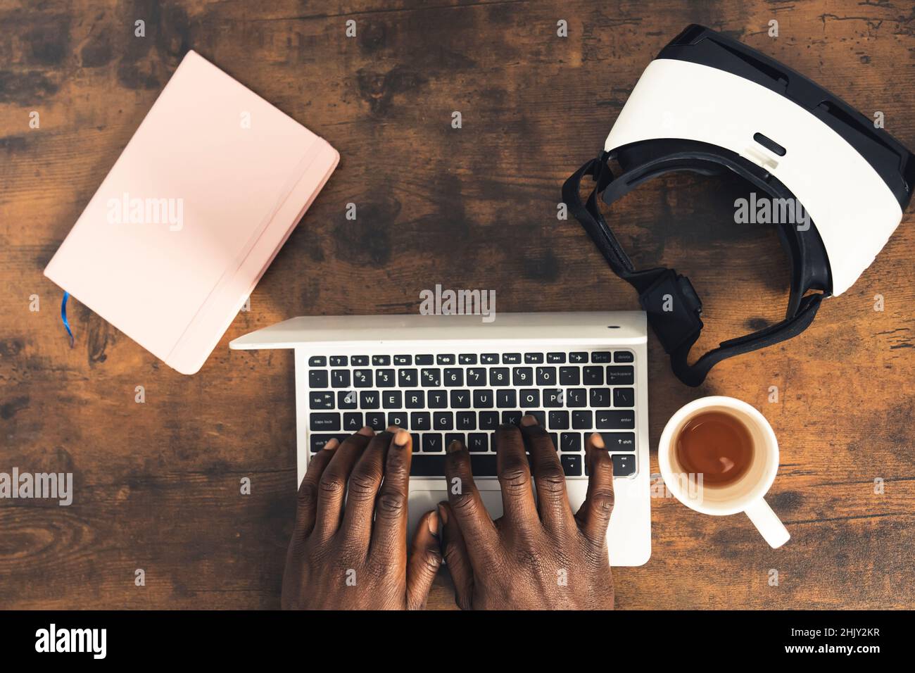 Dark wood working desk man writing on computer laptop with notebook VR ...