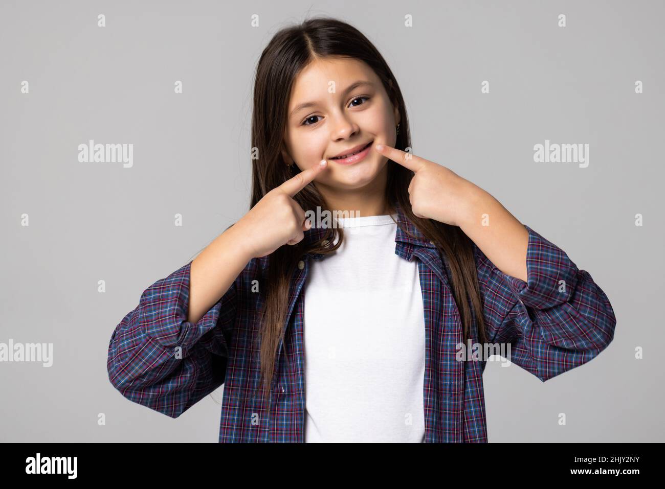 Overjoyed cute small preschooler girl in glasses isolated on grey ...