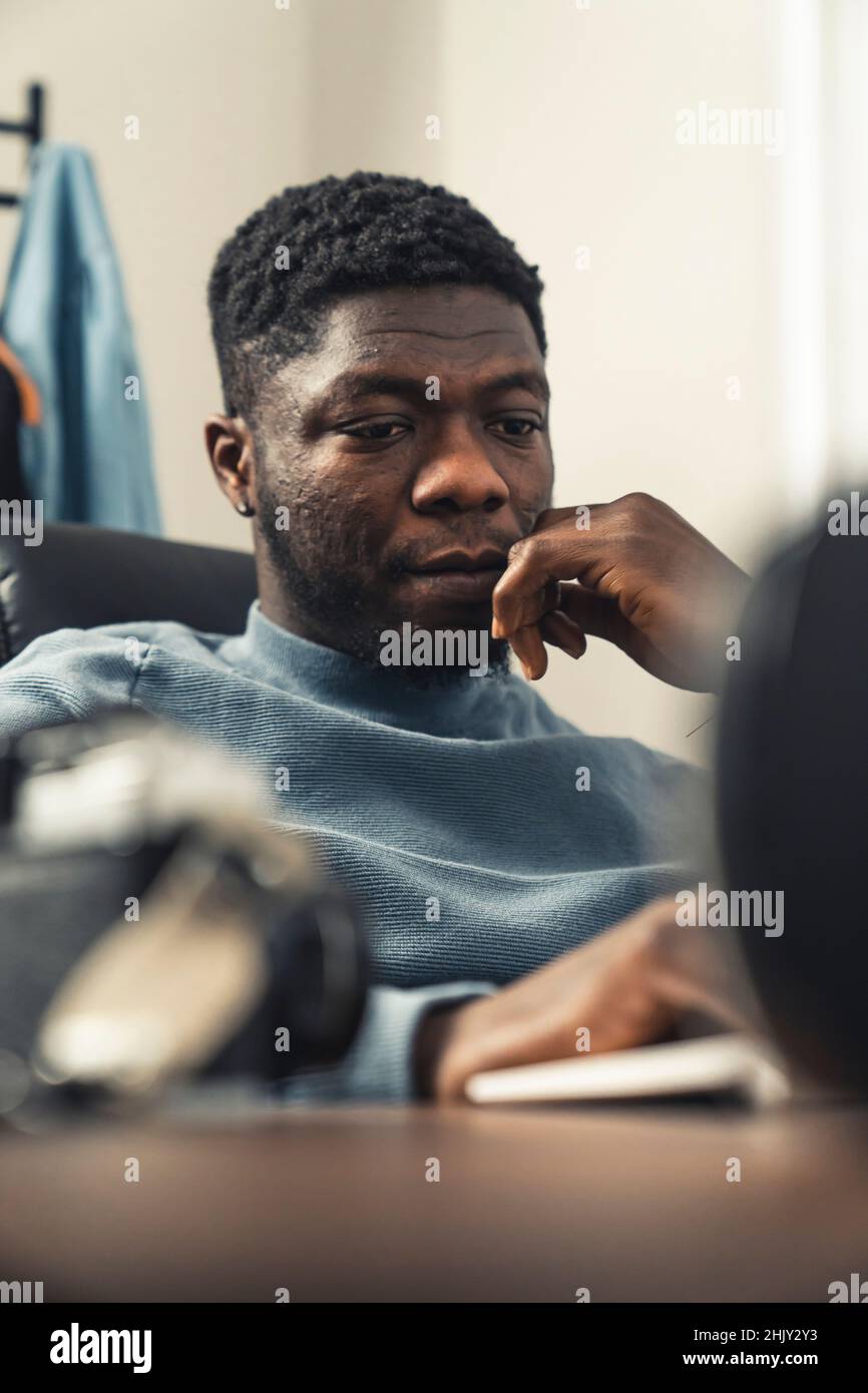 Focused thinking black man working on laptop computer - portrait shot ...