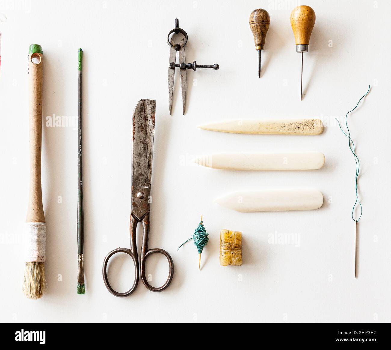 Selection of traditional Book binders tools arranged on cream paper ...