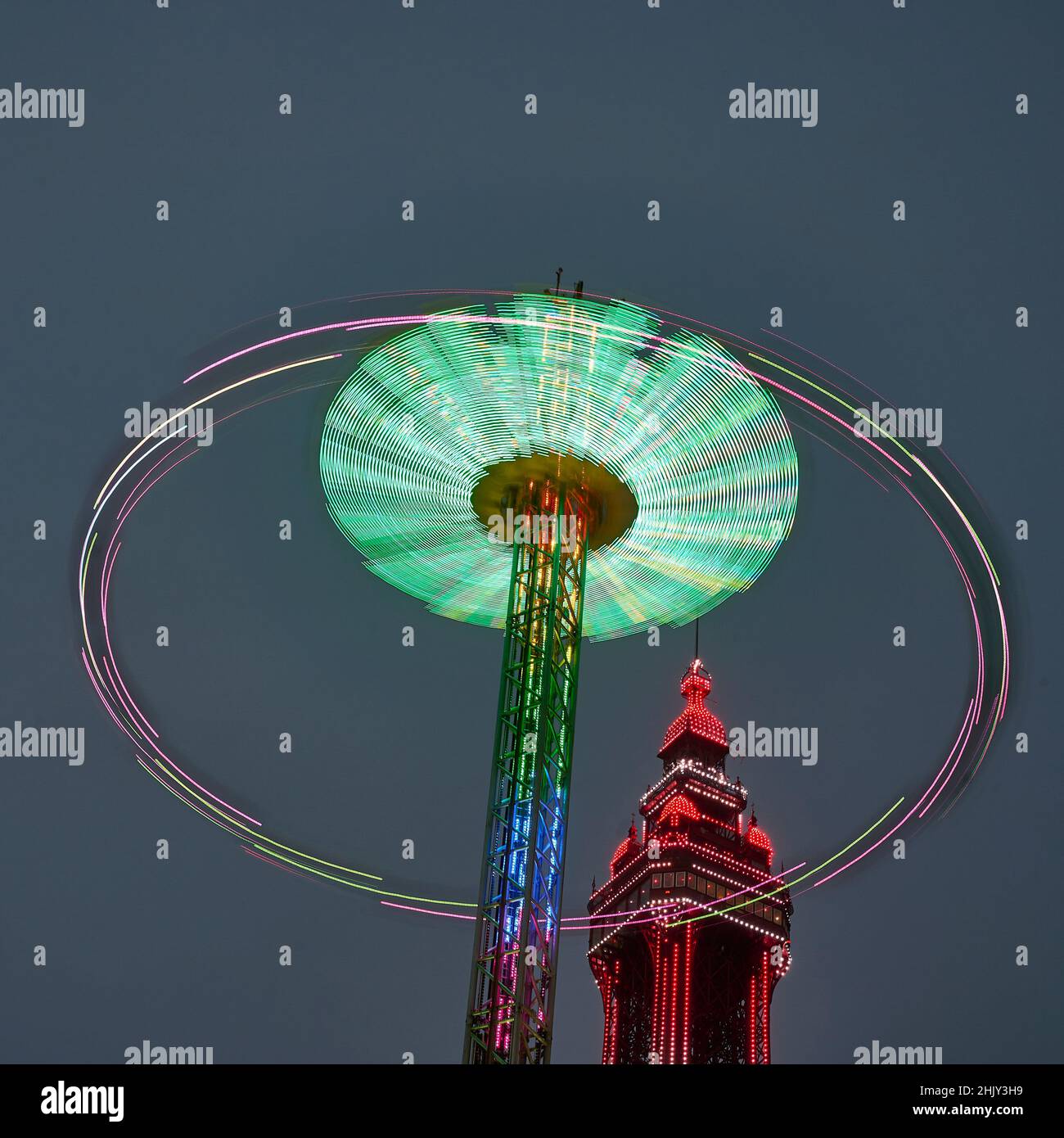 The Star Flyer ride and Blackpool Tower at dusk Stock Photo - Alamy