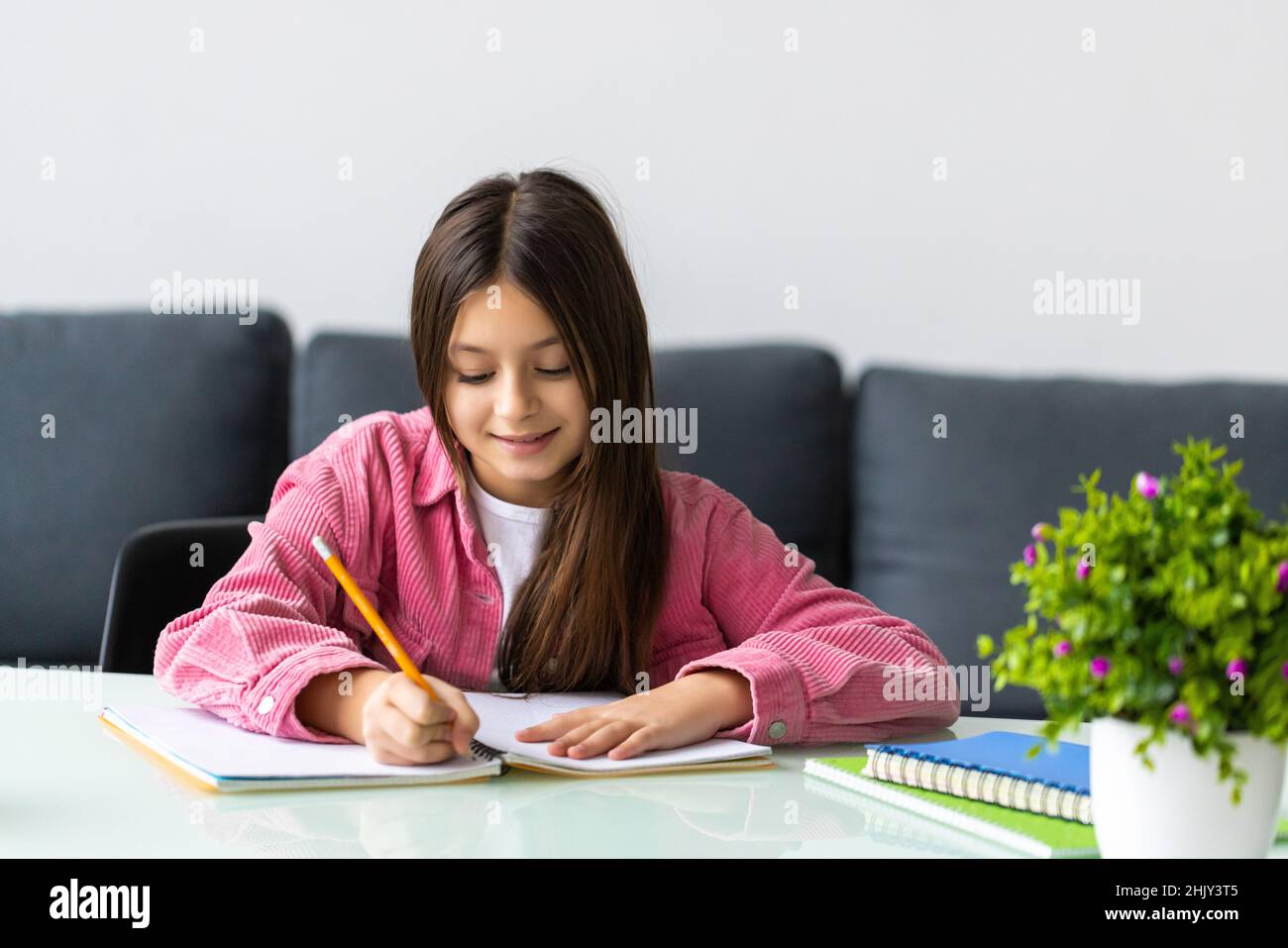 Unhappy little Caucasian girl child sit at table at home feel lazy ...