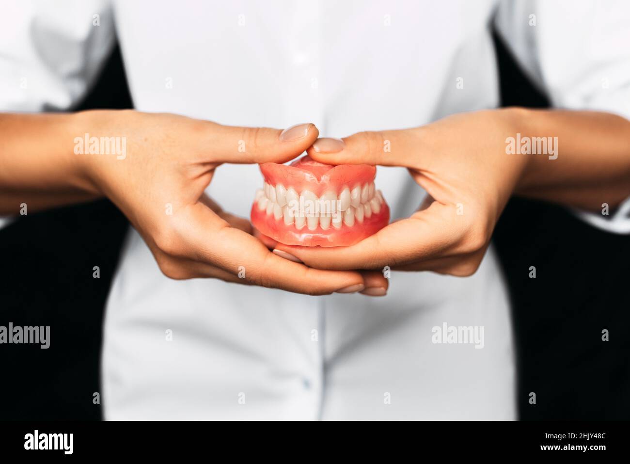 The dentist is holding dentures in his hands. Dental prosthesis in the ...