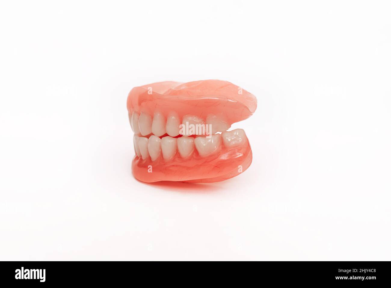 Full removable plastic denture of the jaws. Set of dentures on a white ...