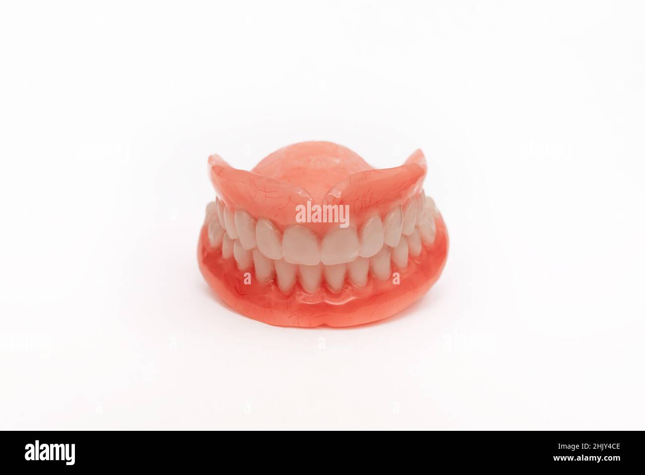 Full removable plastic denture of the jaws. Set of dentures on a white ...