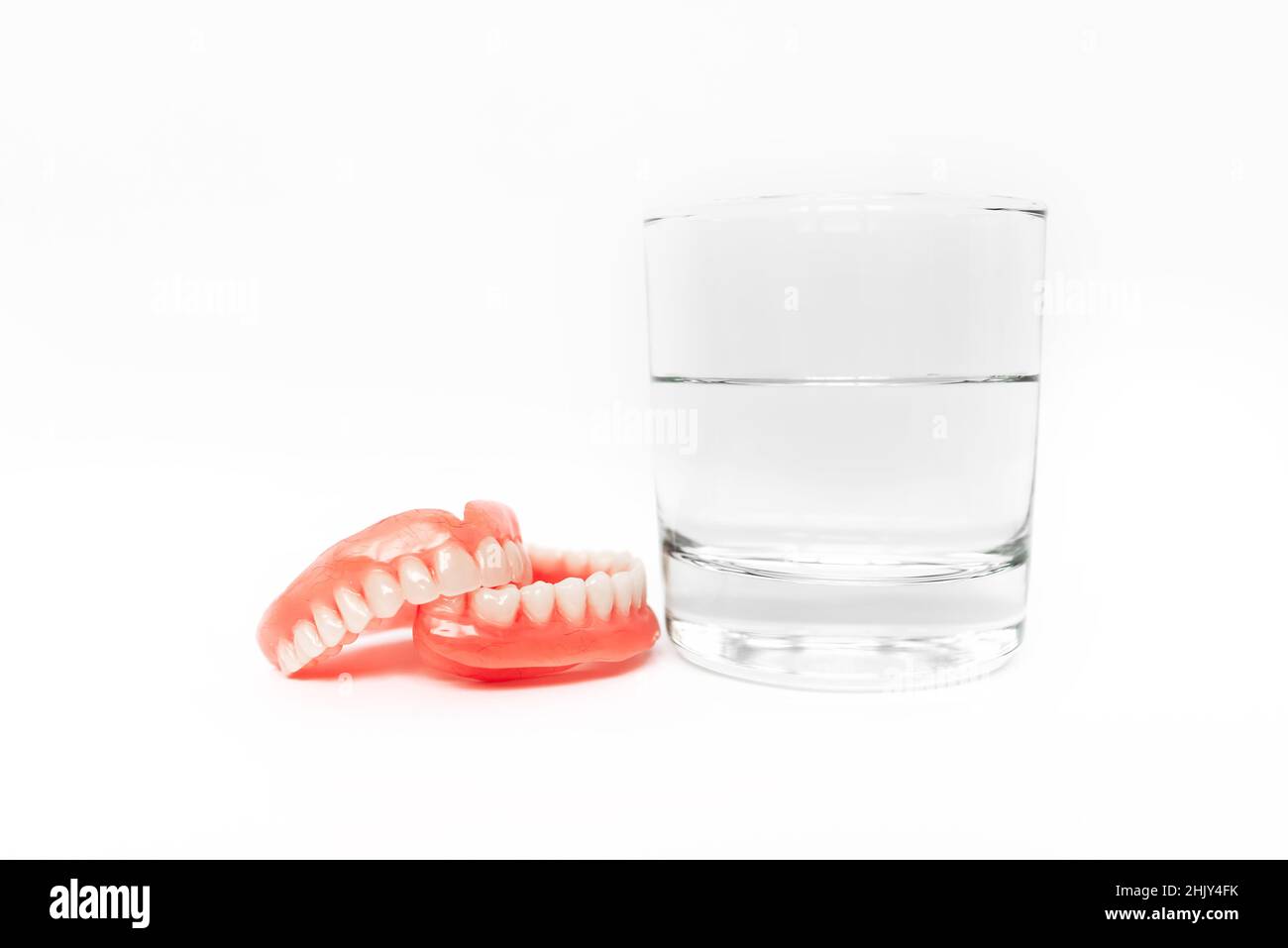 A denture in a glass of water. Dental prosthesis care. Full removable ...