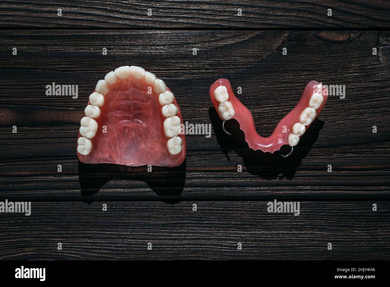 Full removable plastic denture of the jaws. A set of dentures on a dark ...