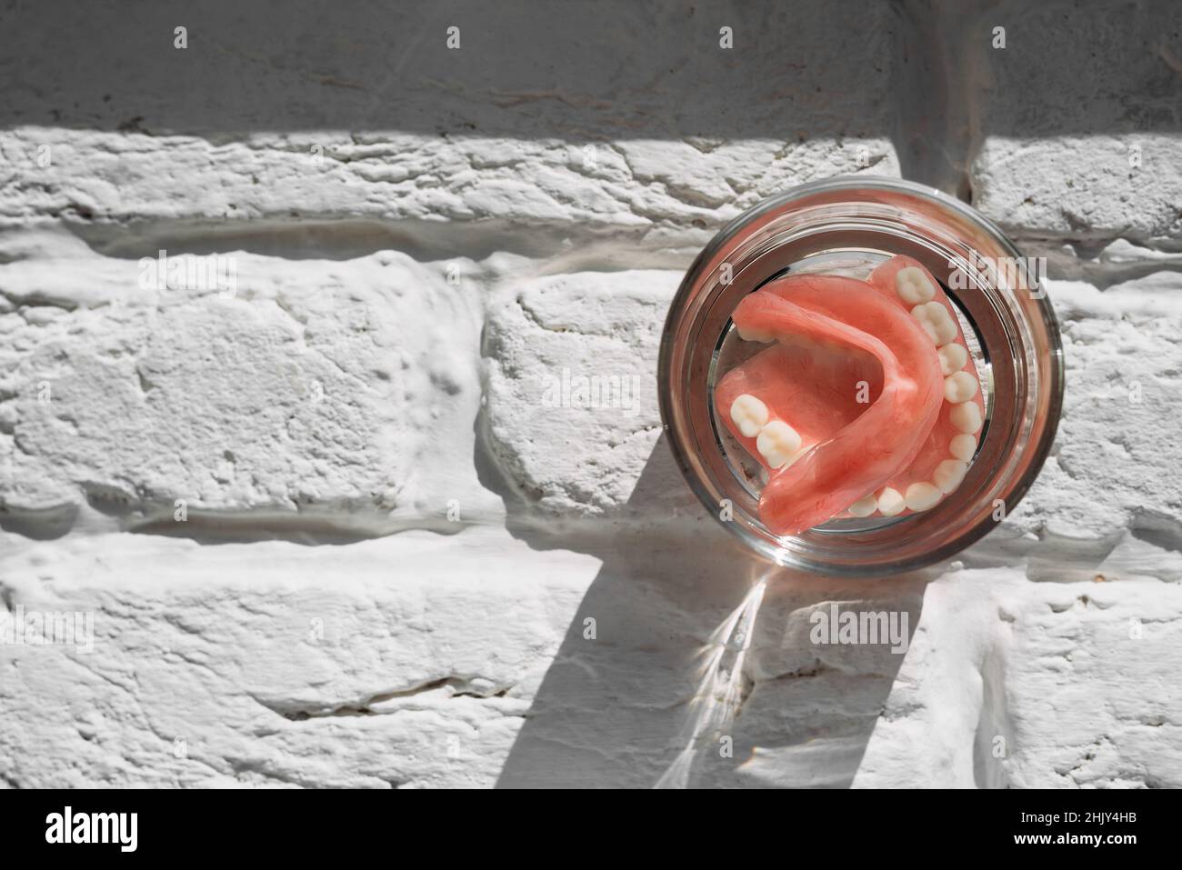 Prosthesis in a glass with a solution. Dental prosthesis care. Full ...