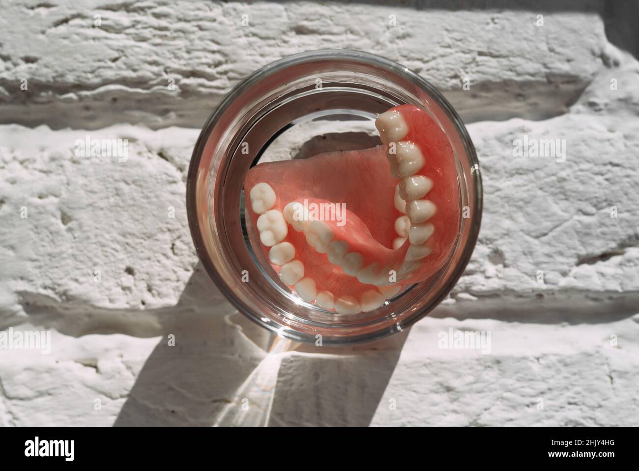Prosthesis in a glass with a solution. Dental prosthesis care. Full ...