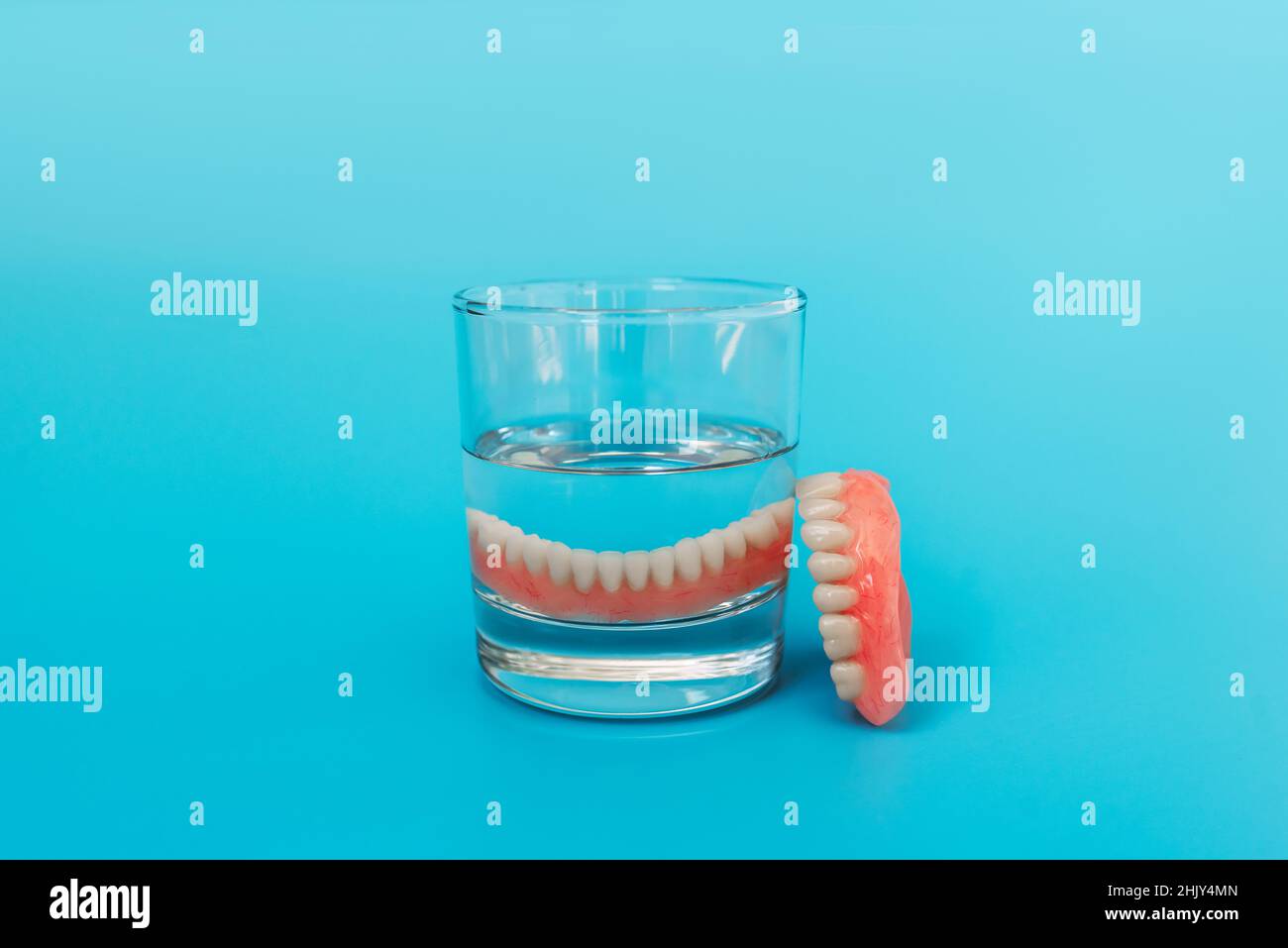 Prosthesis in a glass with a solution. Dental prosthesis care. Full ...
