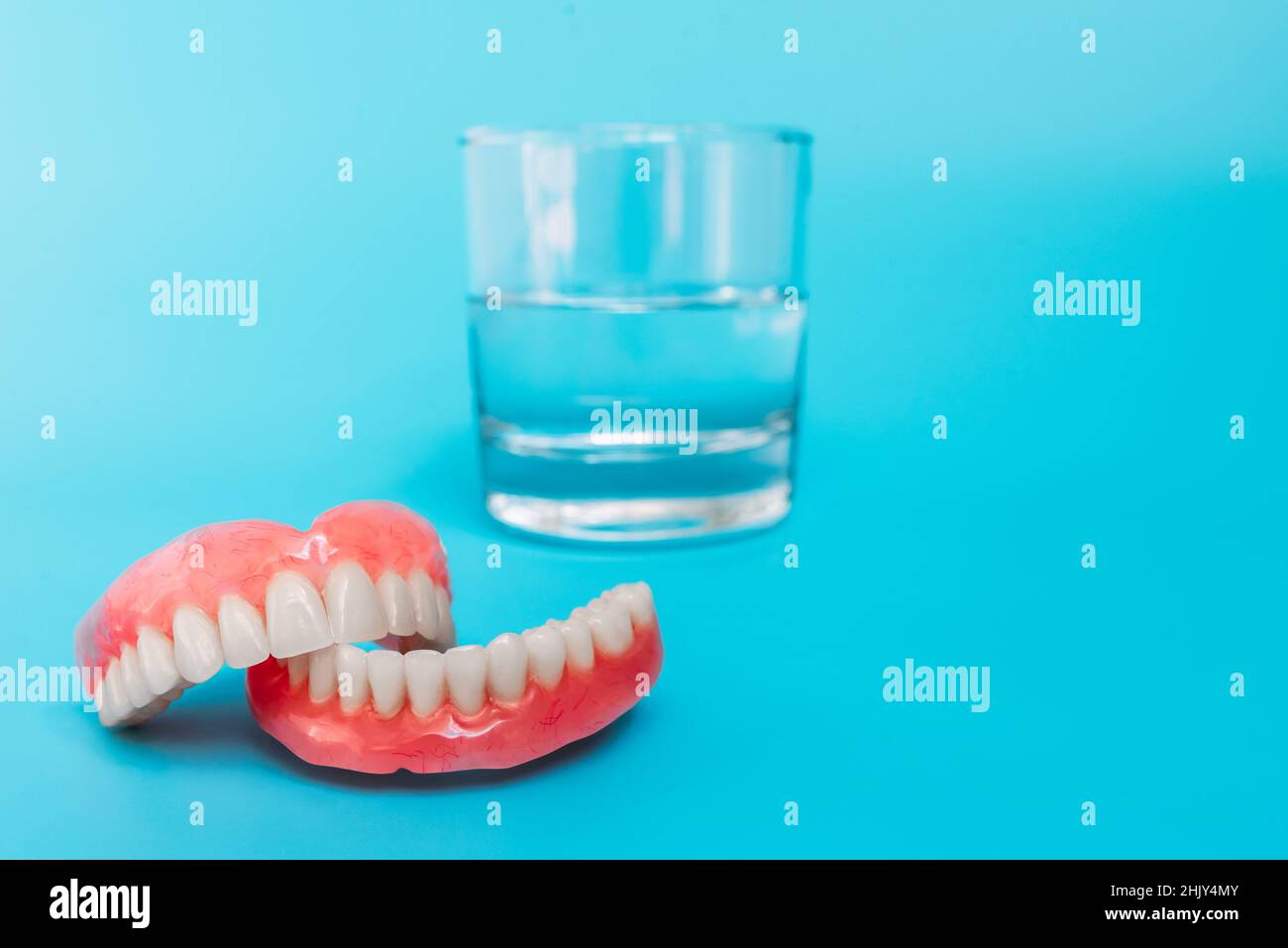 A prosthesis and a glass with a solution. Dental prosthesis care. Full ...