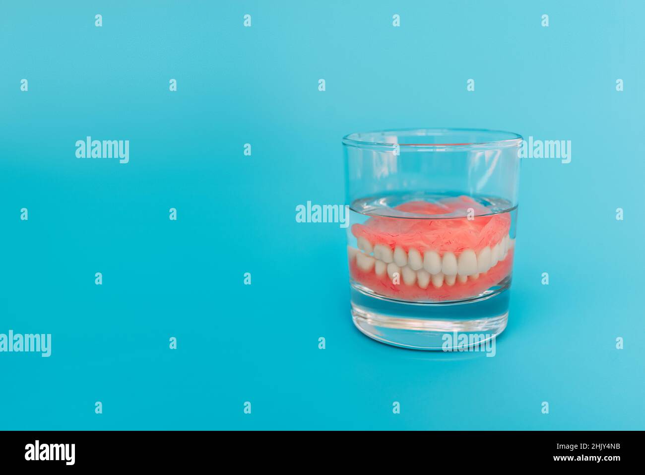 Prosthesis in a glass with a solution. Dental prosthesis care. Full ...
