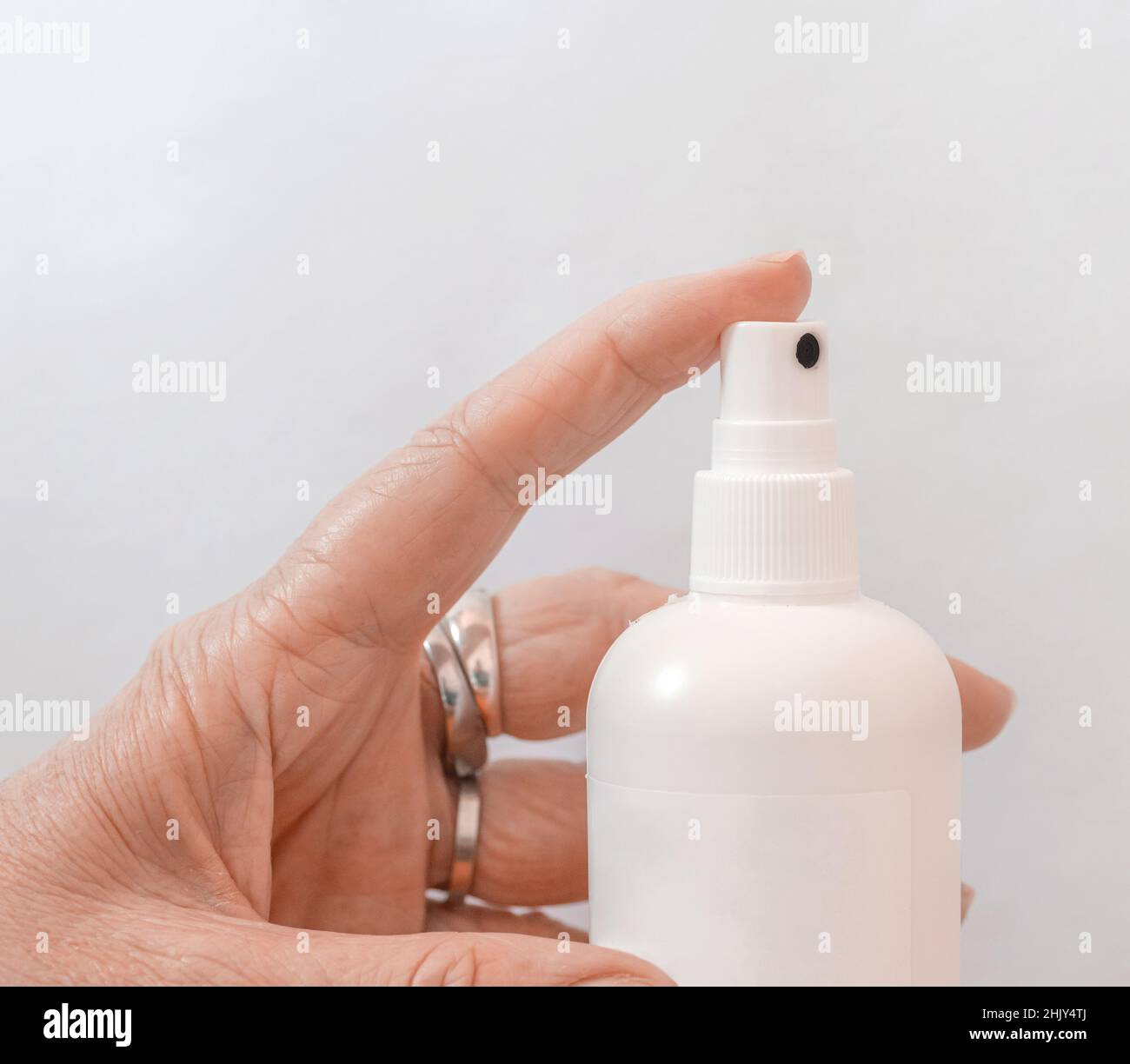 Finger of a woman holding bottle sntibacterial spray for sterilization ...