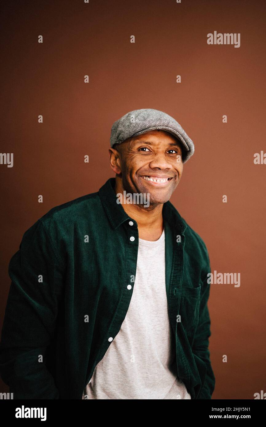 Smiling man standing over brown background Stock Photo - Alamy