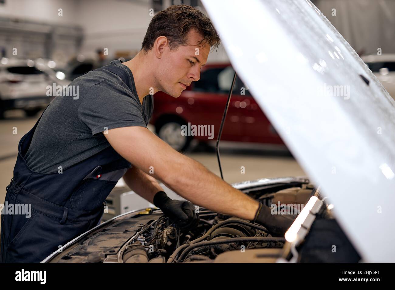 auto mechanic looking inside of engine in garage. Car motor repair ...