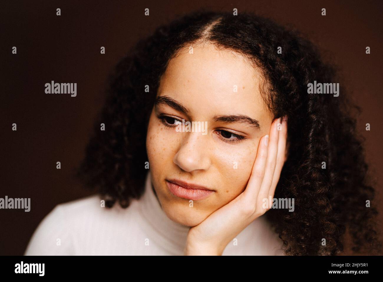 Contemplative young woman curly hi-res stock photography and images - Alamy
