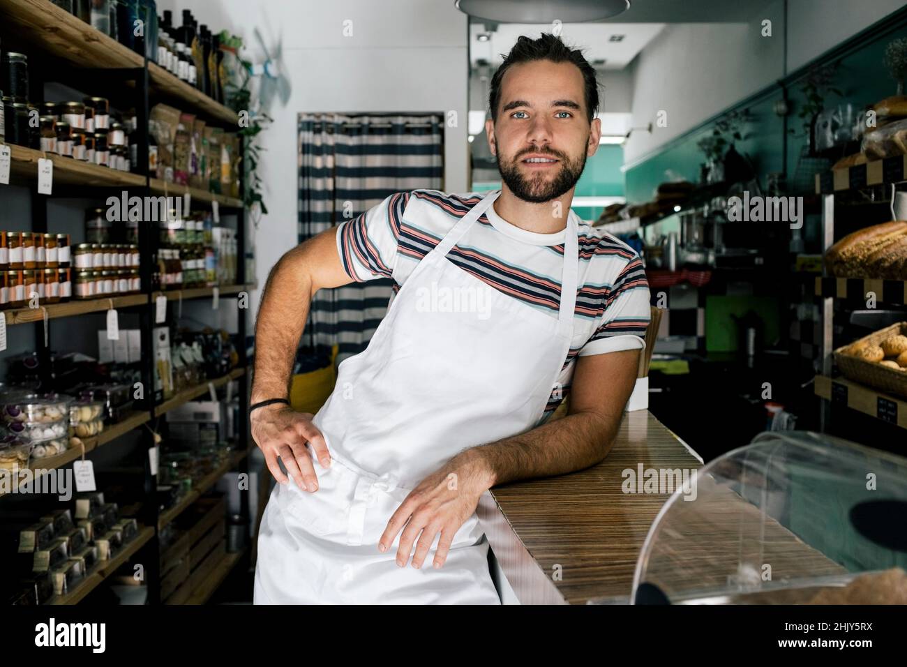 Portrait of male owner leaning at counter in cafe Stock Photo - Alamy