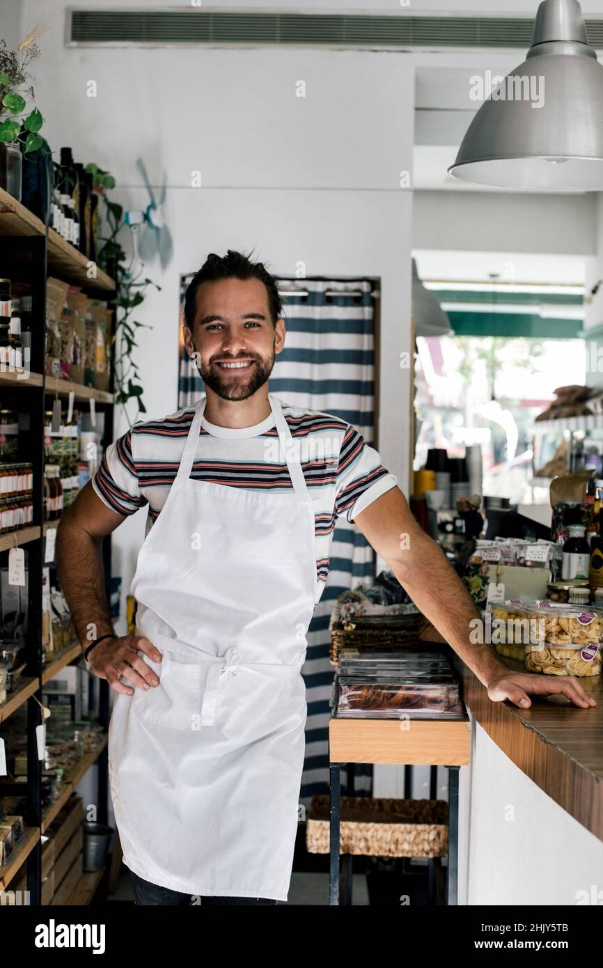 Portrait of smiling male entrepreneur with hand on hip in bakery Stock ...
