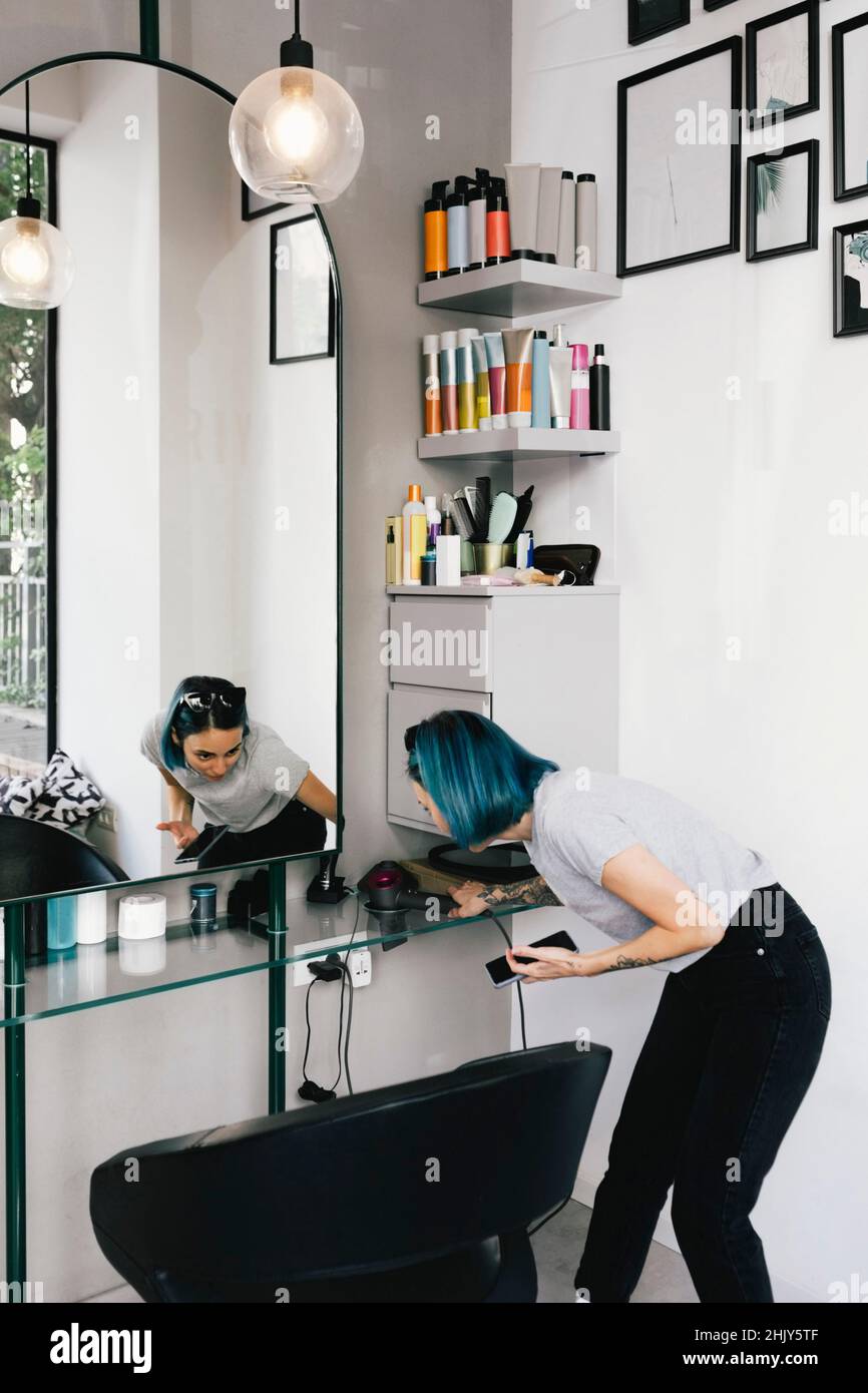 Mid adult female owner working in salon Stock Photo - Alamy
