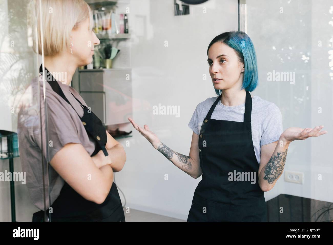 Female owner talking with coworker in hair salon Stock Photo - Alamy
