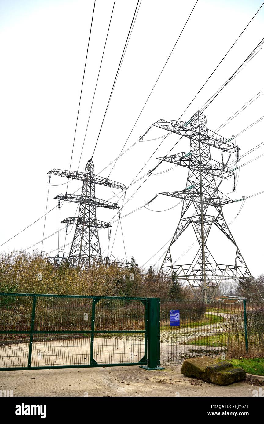 Two electricity pylons and powerlines against the sky at sub station ...