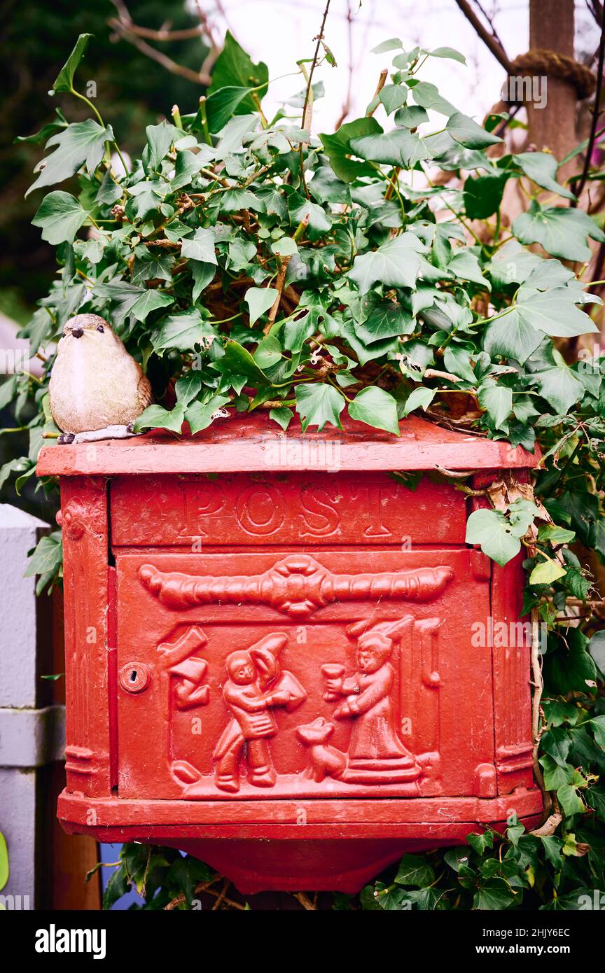 Plastic robin sat on red mail box attached to gate post of house Stock ...