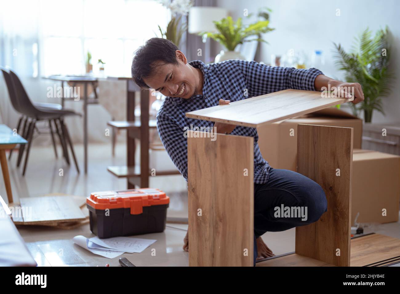 happy man while working on assembling new furniture Stock Photo - Alamy