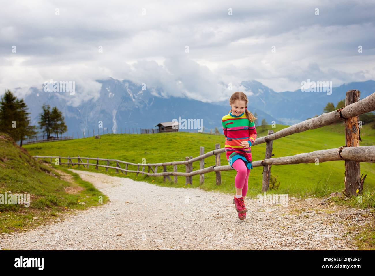 Children hiking in Alps mountains. Kids look at snow covered mountain ...