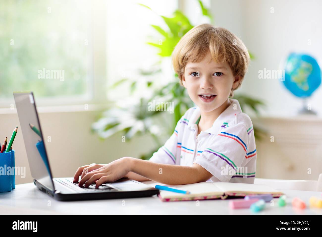 Online remote learning. School kids with computer having video ...
