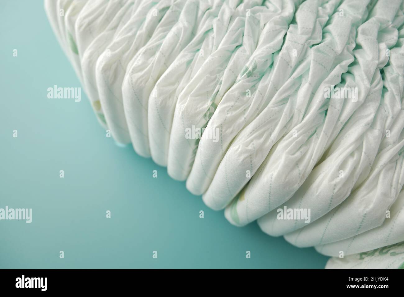 stack of baby diaper on light green background Stock Photo - Alamy