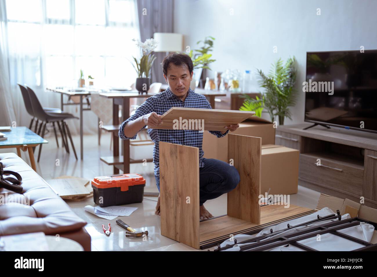 young asian male assembling furniture by himself Stock Photo - Alamy